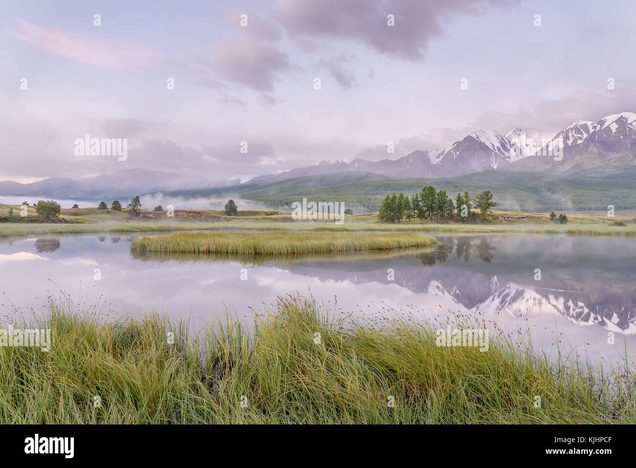 A beautiful delicate landscape on a lake with a picturesque island, fog ...