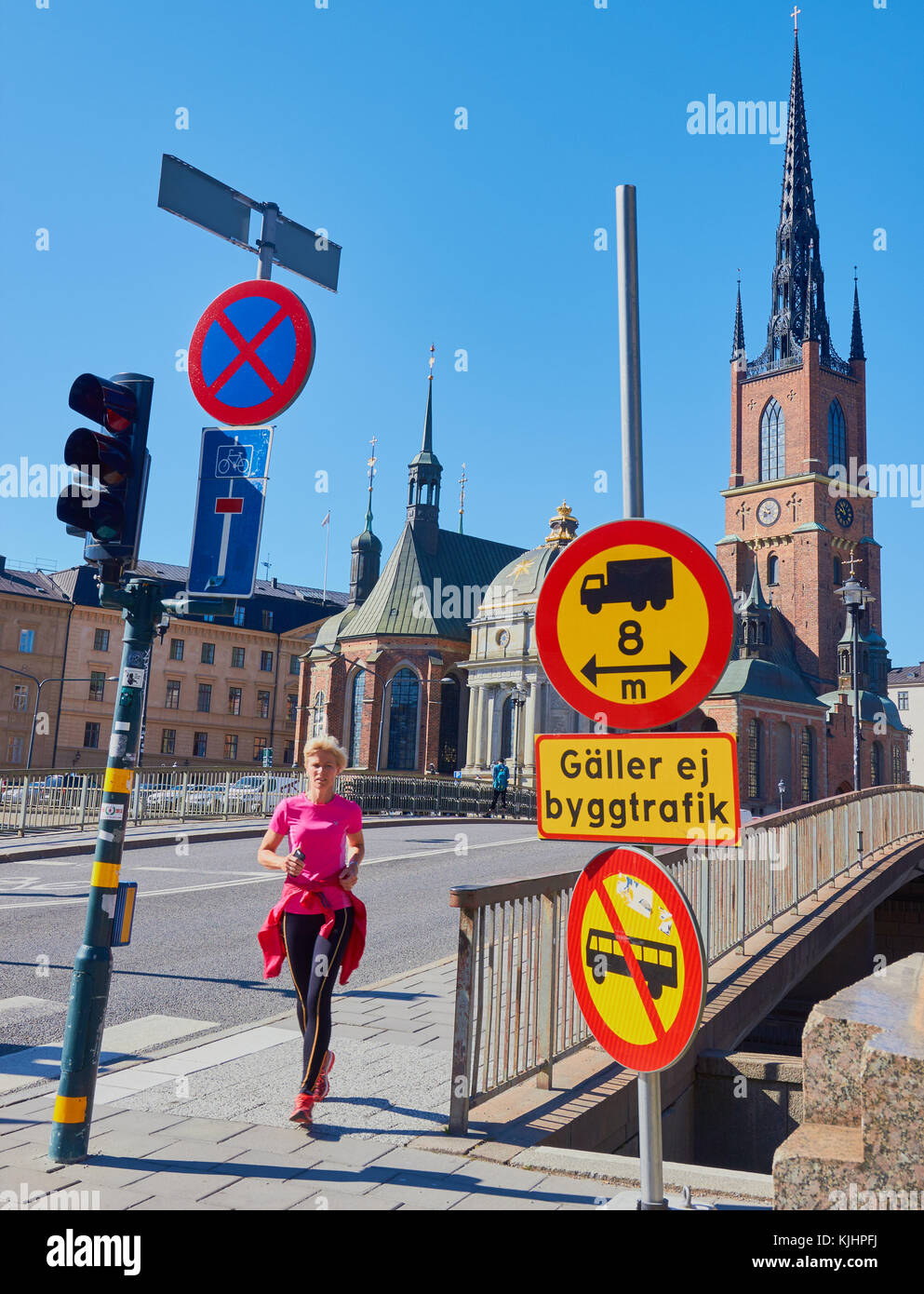 Woman running across bridge with Riddarholmskyrkan in background, Gamla ...
