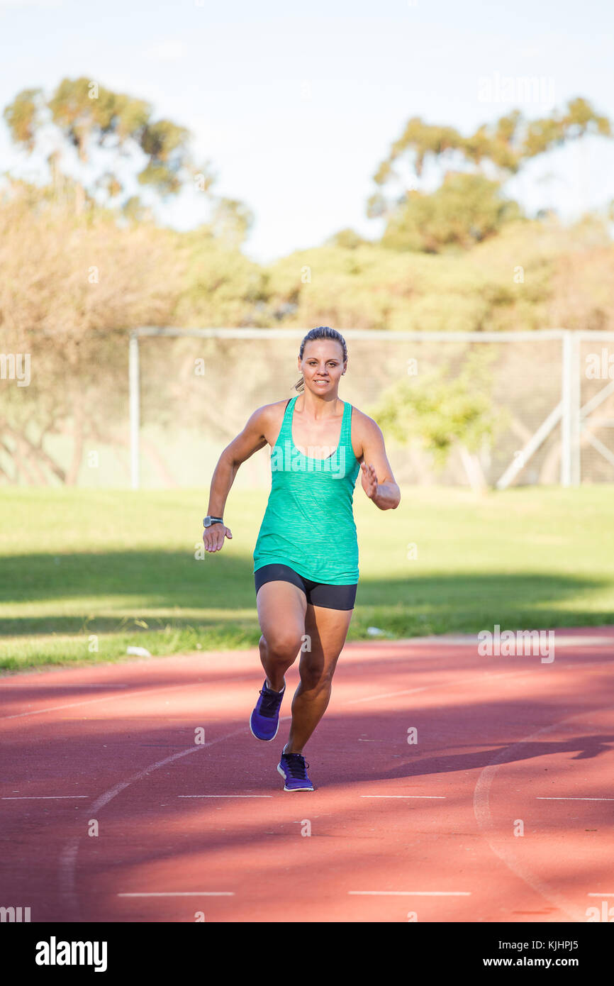 Close up wide angle view of a female sprinter athlete getting ready to ...