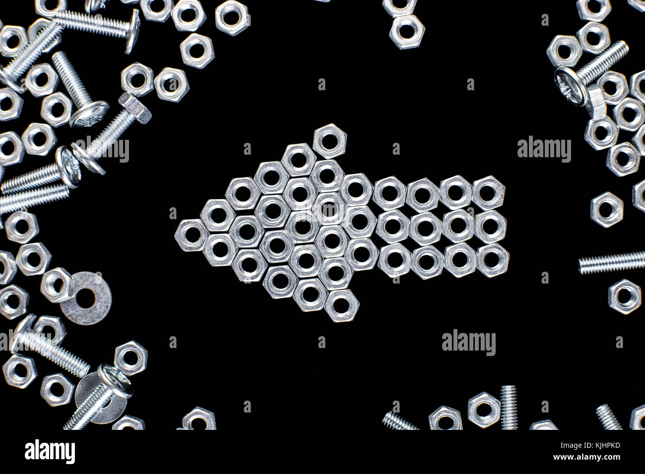Arrow from metal nuts, bolts on black background. Flat lay Stock Photo ...