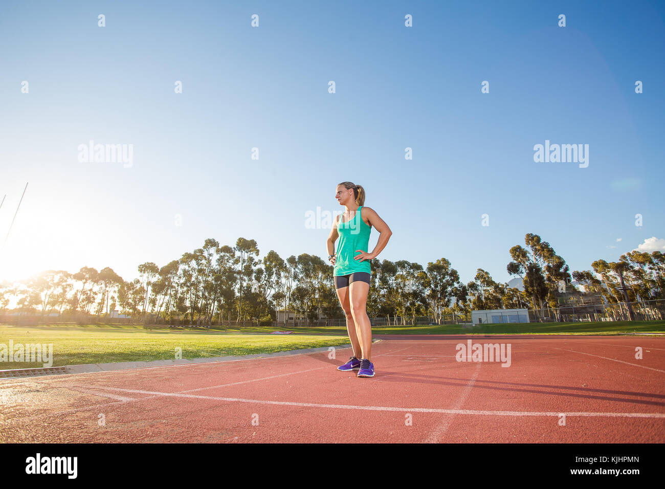 Close up wide angle view of a female sprinter athlete getting ready to ...