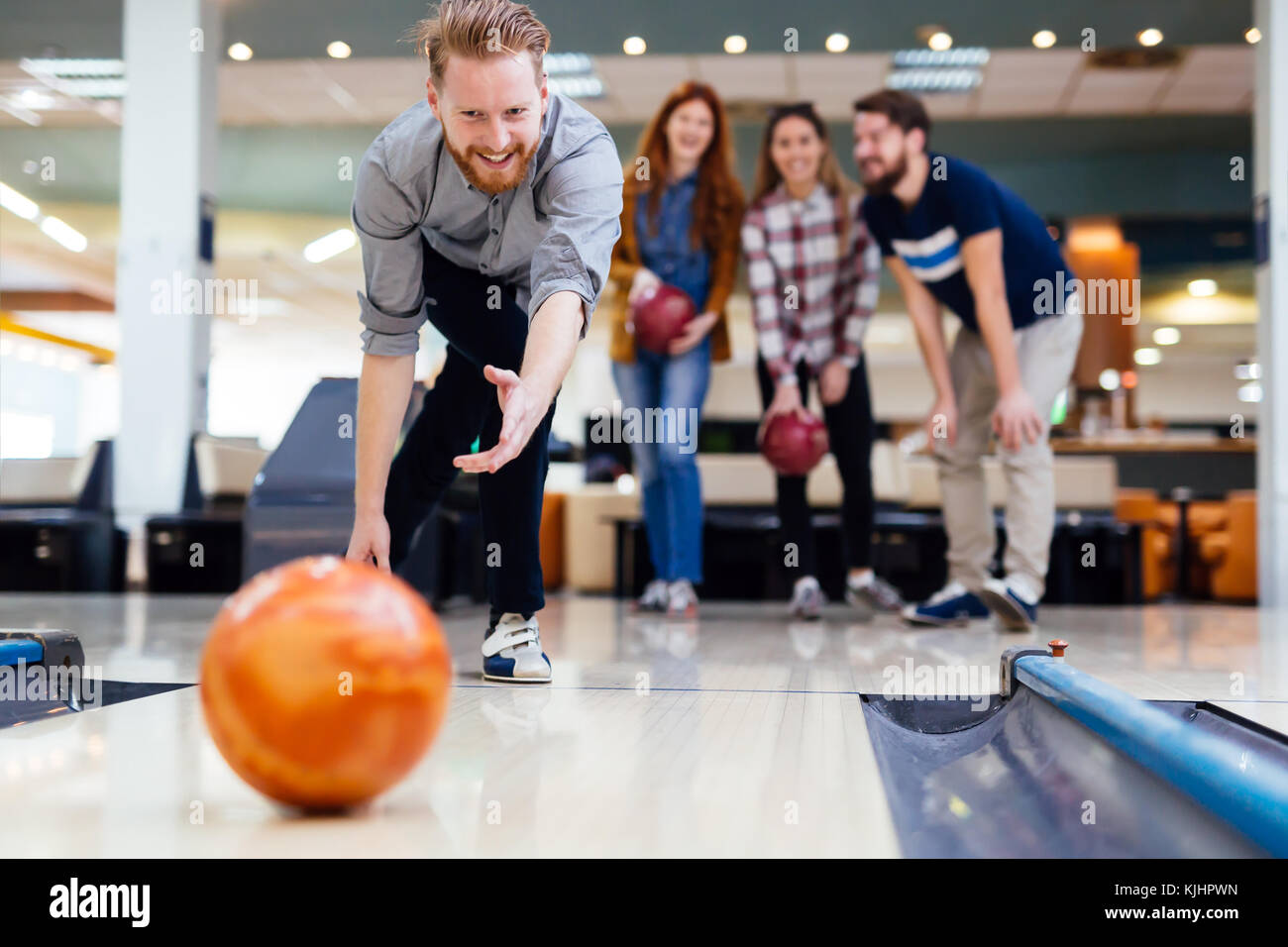 Friends enjoying bowling at club Stock Photo - Alamy