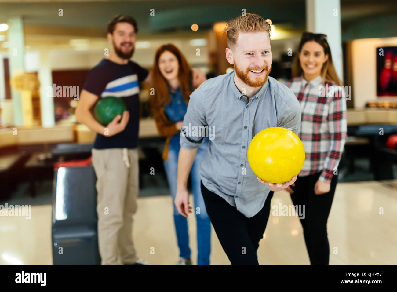Friends bowling at club Stock Photo - Alamy