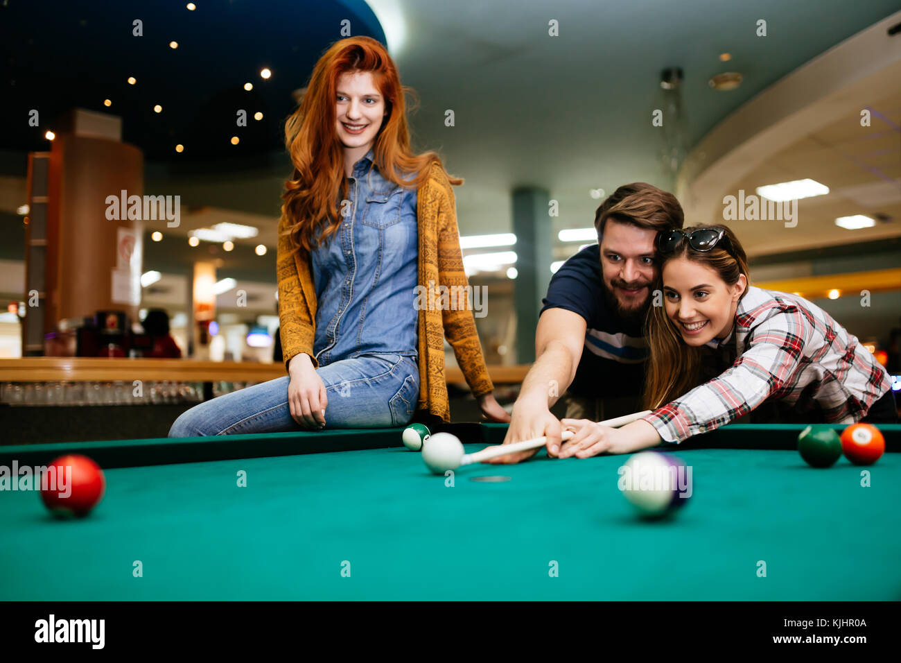 Happy friends enjoying playing pool Stock Photo - Alamy