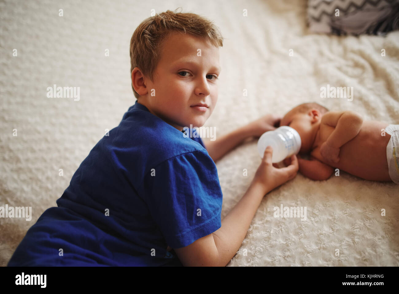 boy feeding newborn baby with bottle of milk Stock Photo - Alamy