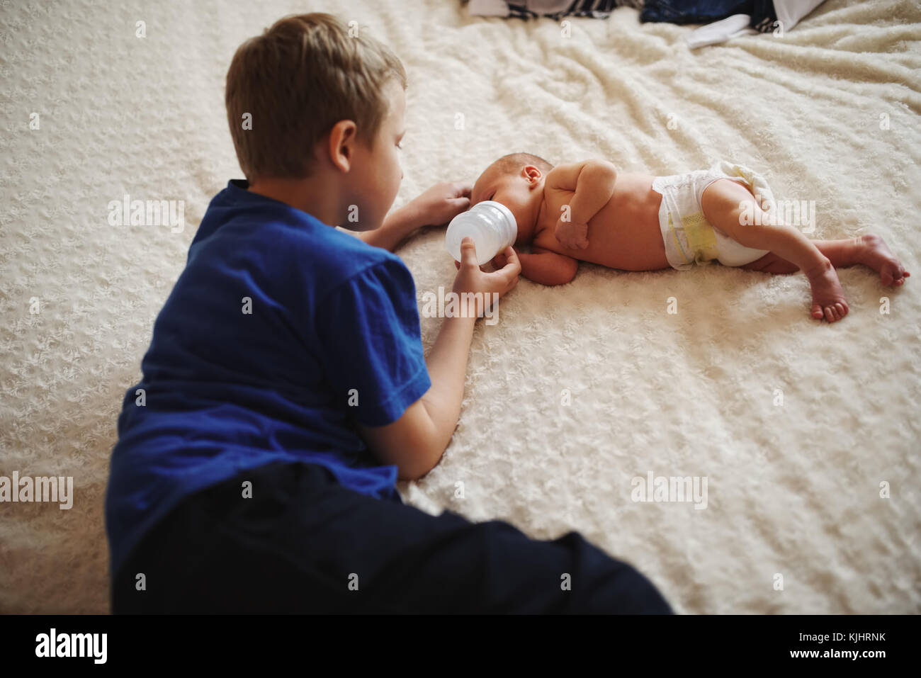 boy feeding newborn baby with bottle of milk Stock Photo - Alamy