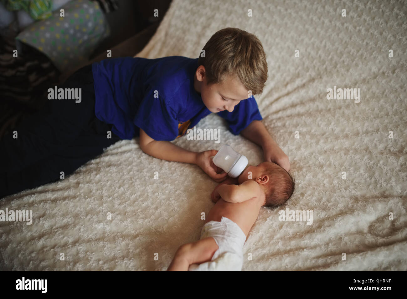 boy feeding newborn baby with bottle of milk Stock Photo - Alamy