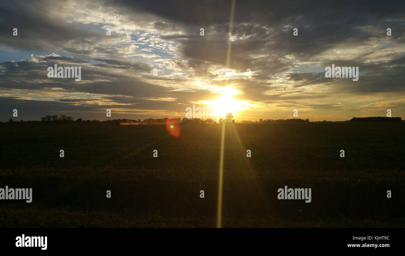 A beautiful Sunset in Henderson, Michigan, with a combine harvesting in ...