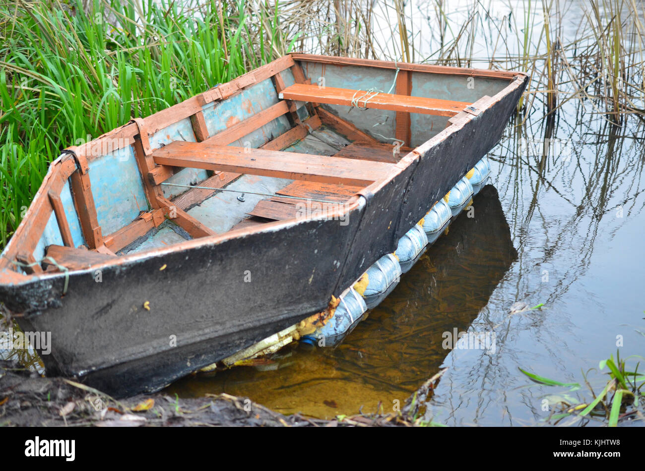 A dilapidated boat moored on the river bank by an iron chain Stock ...