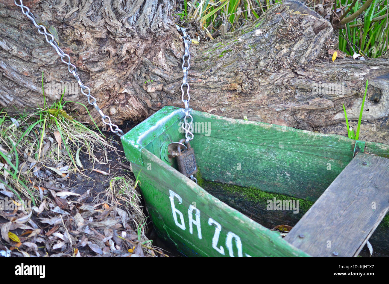 The old boat is tied to a tree trunk by a chain Stock Photo - Alamy