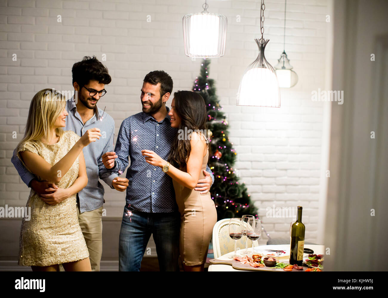 Group of smiling people holding sparklers on Christmas Eve Stock Photo ...