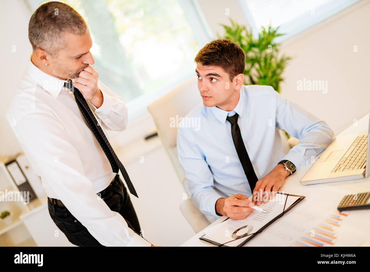 Two businessman talking and working in the office Stock Photo - Alamy