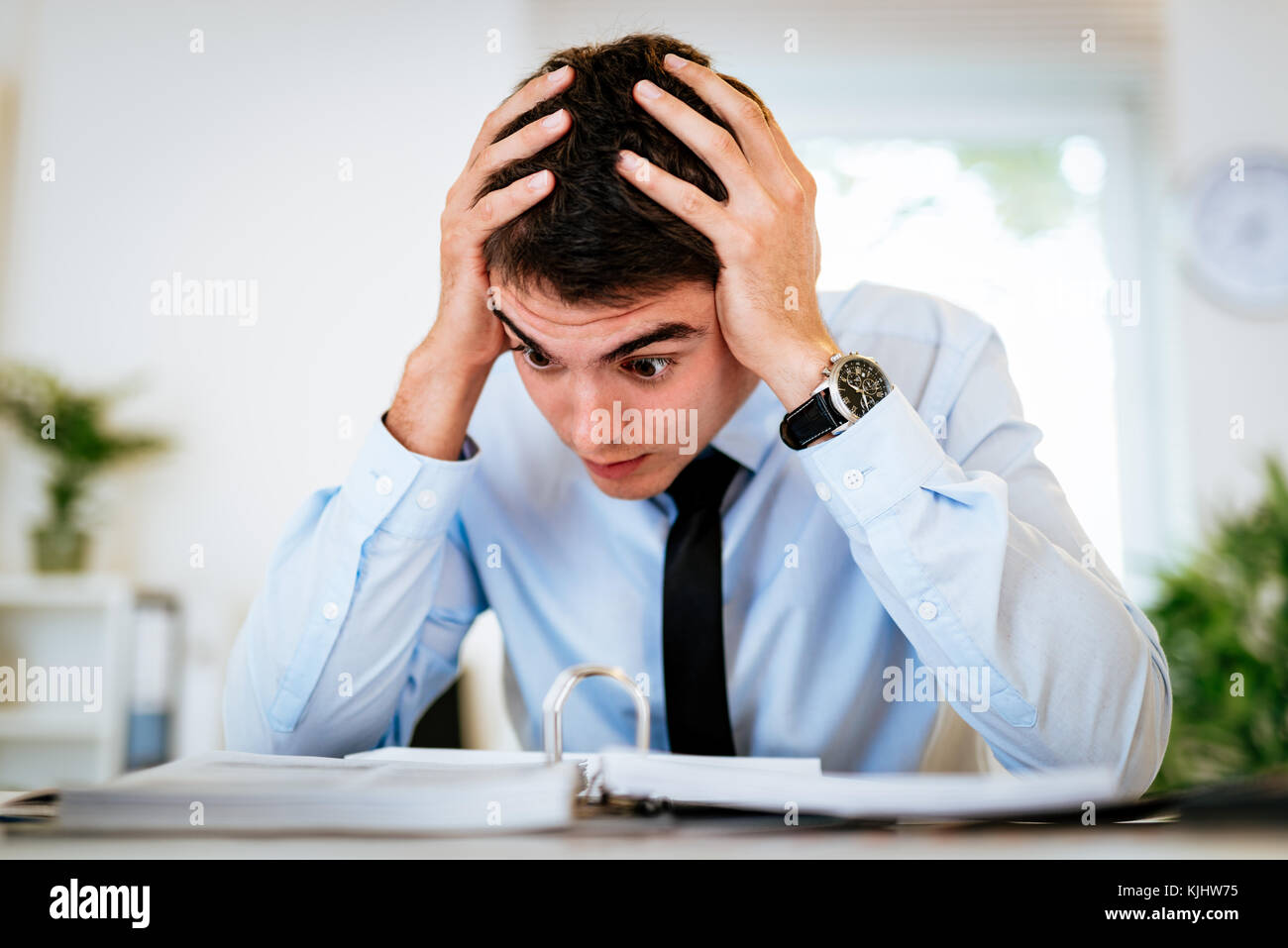 Young handsome stressed businessman working in the office Stock Photo ...