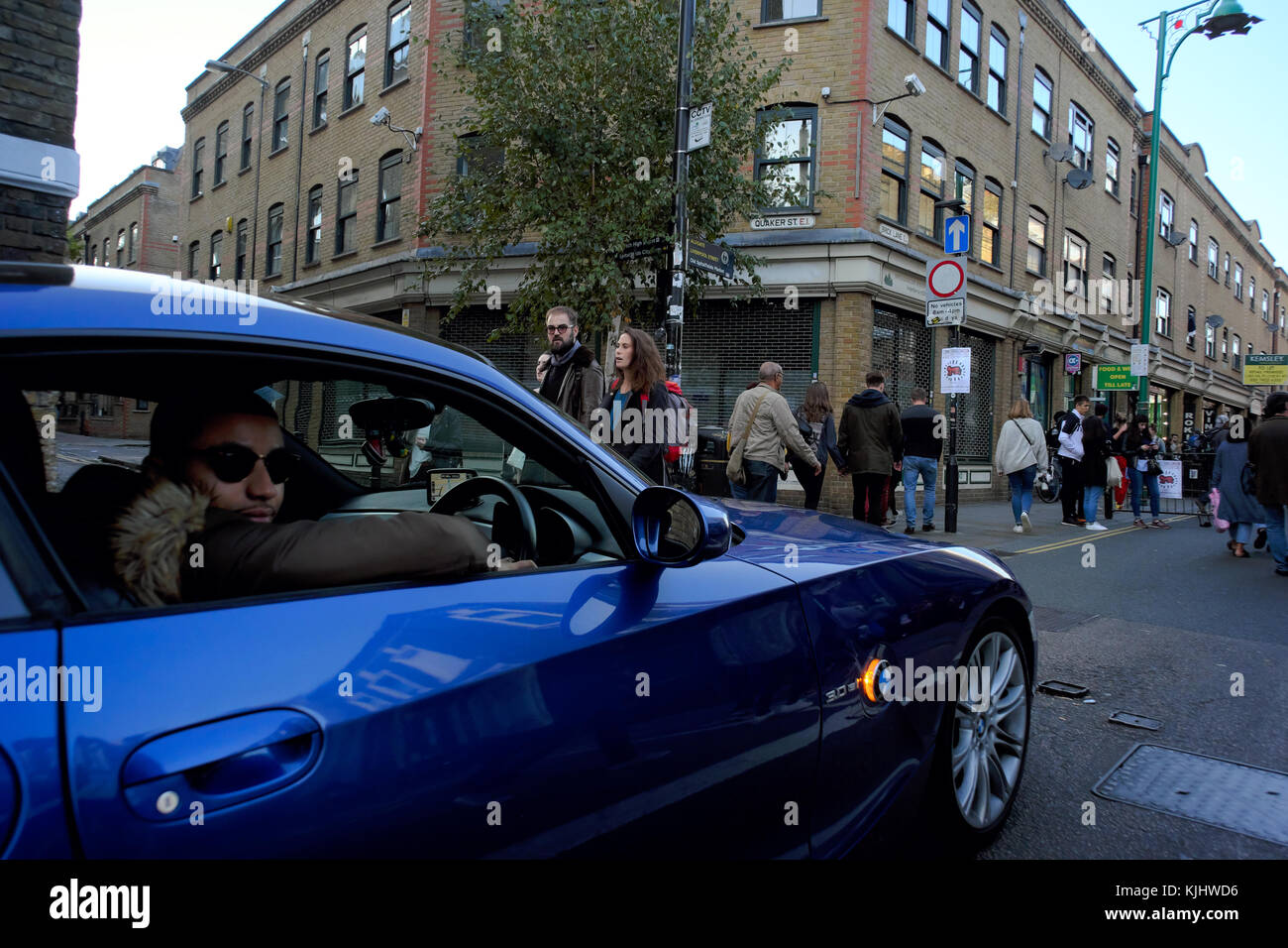 Young asian man cruising down Brick Lane in his BMW car in Shoreditch ...