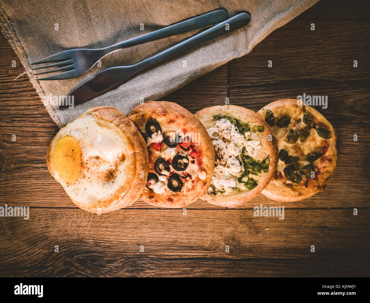 Four pizzettes in a row Stock Photo - Alamy