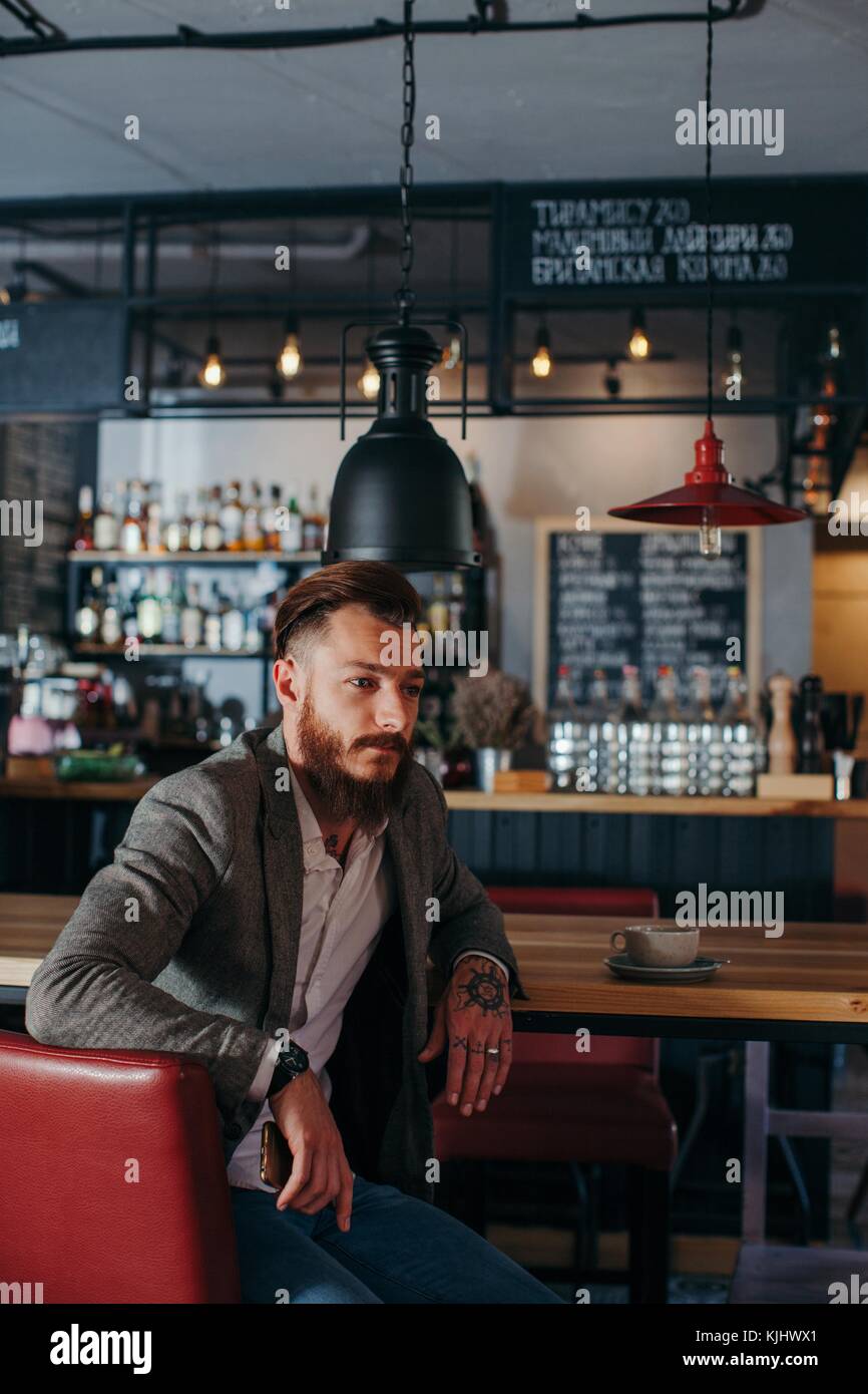 Portrait of a man sitting in a bar Stock Photo - Alamy