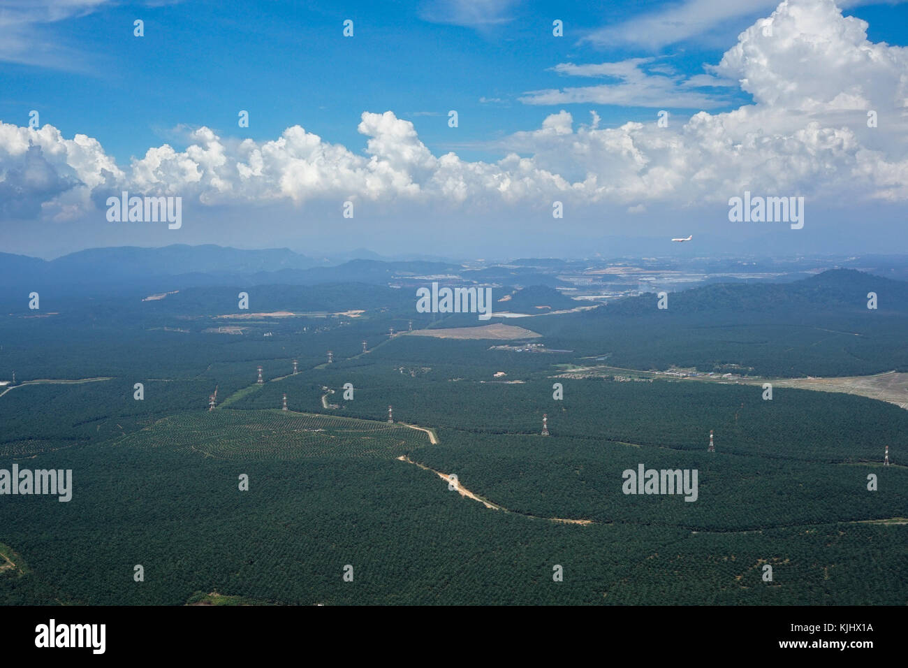 Plane flying over power lines in rural landscape, Sepang, Malaysia ...