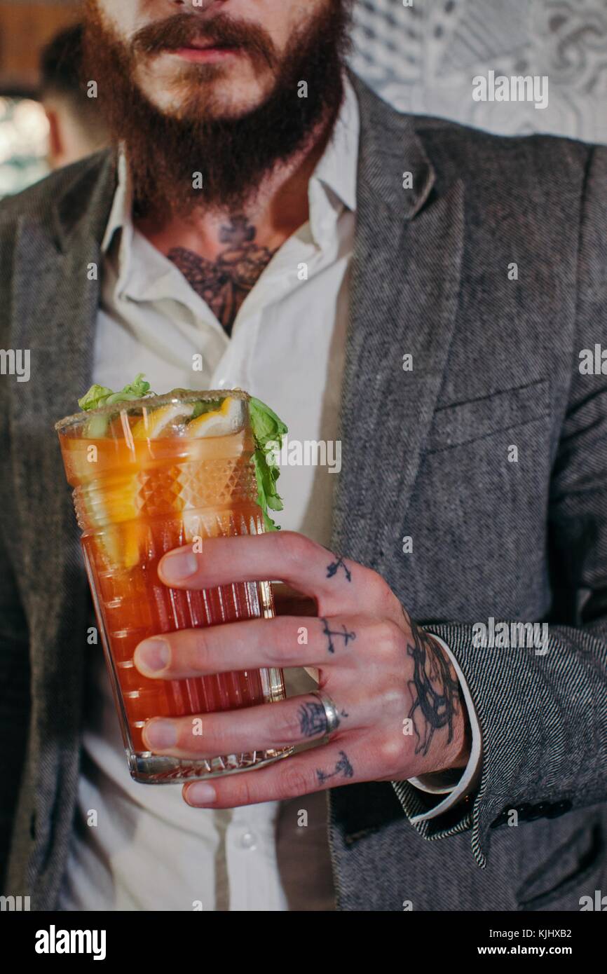 Man in a bar holding a cocktail Stock Photo - Alamy