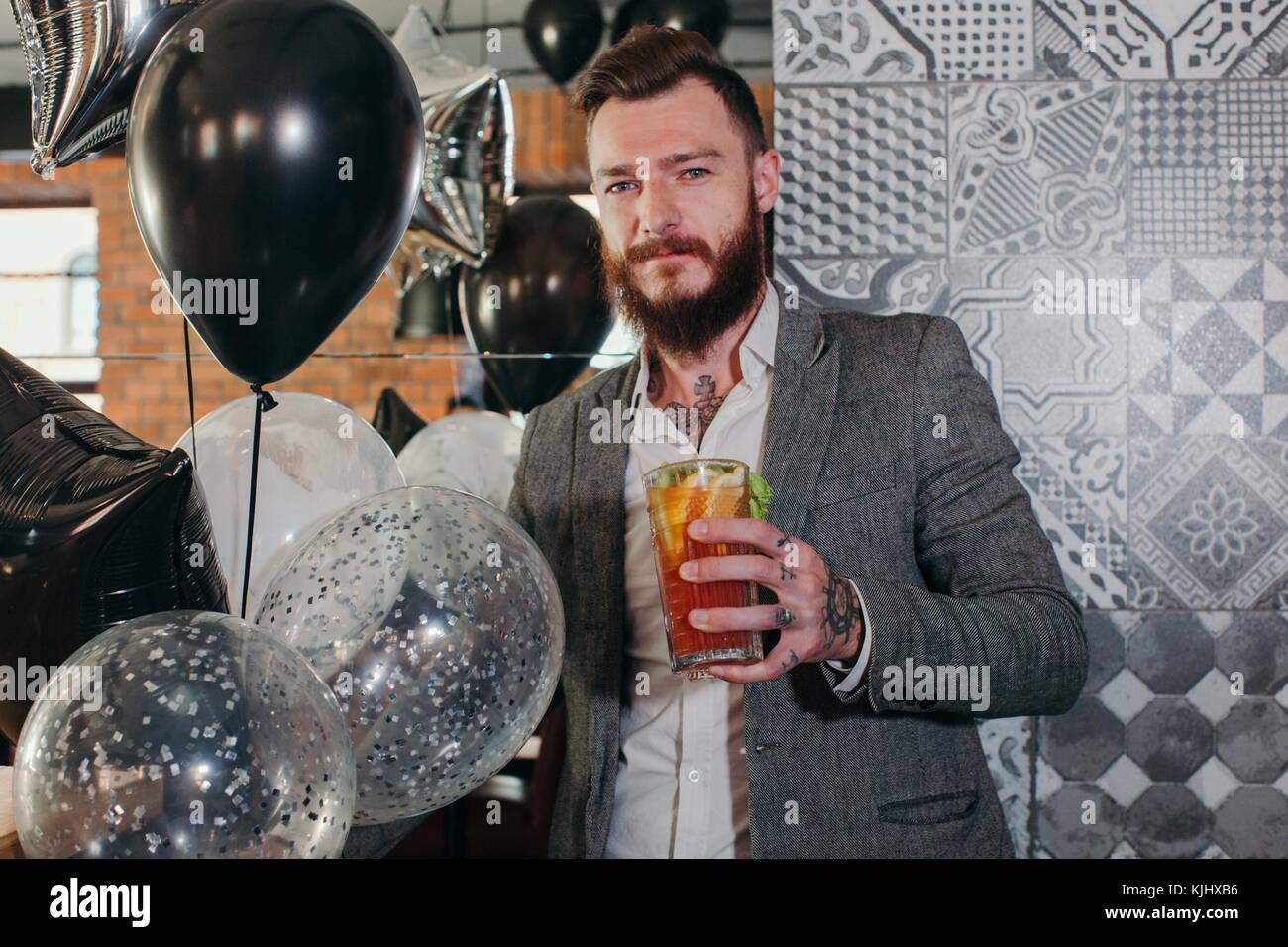 Man in a bar holding a cocktail Stock Photo - Alamy
