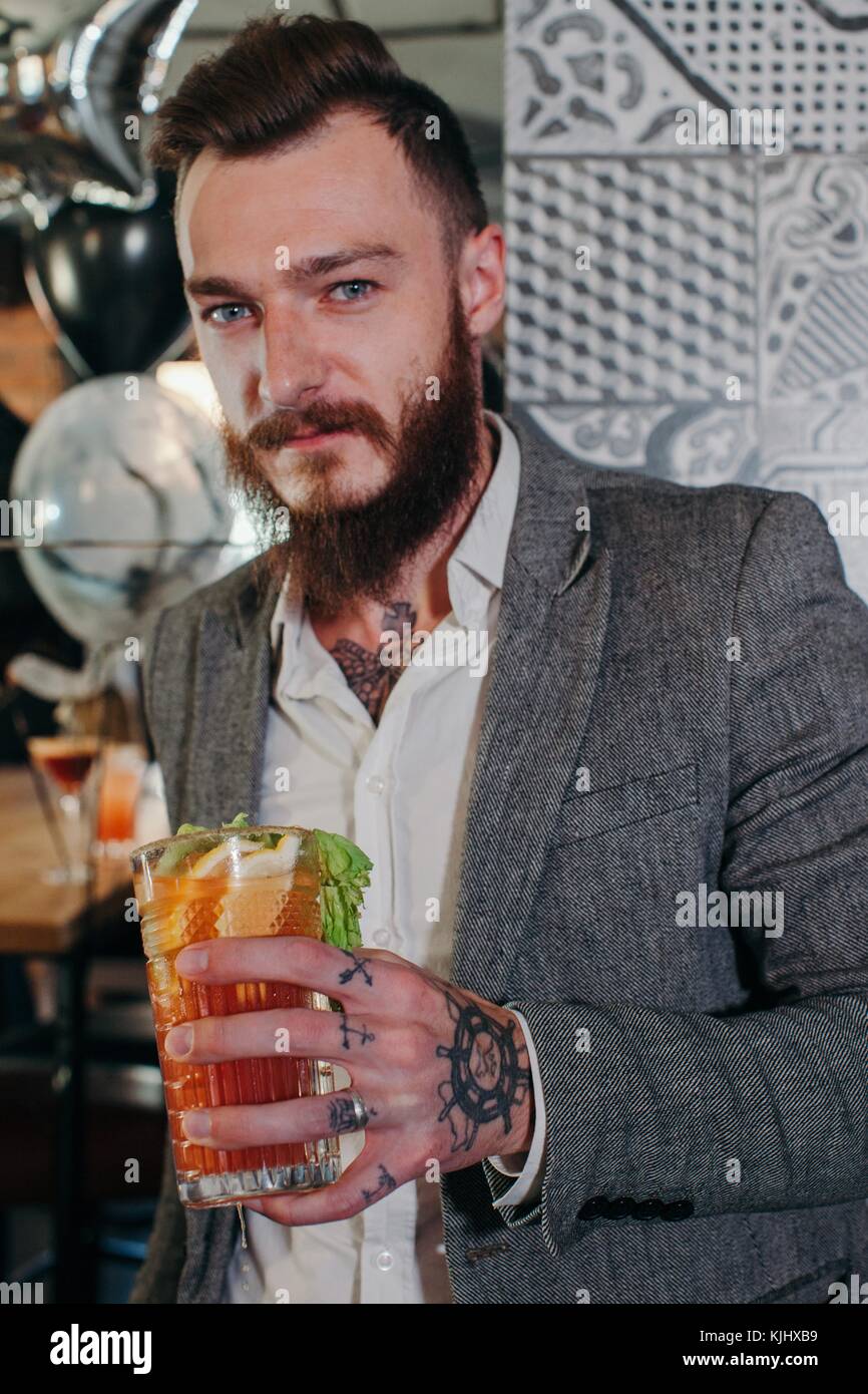 Man in a bar holding a cocktail Stock Photo - Alamy
