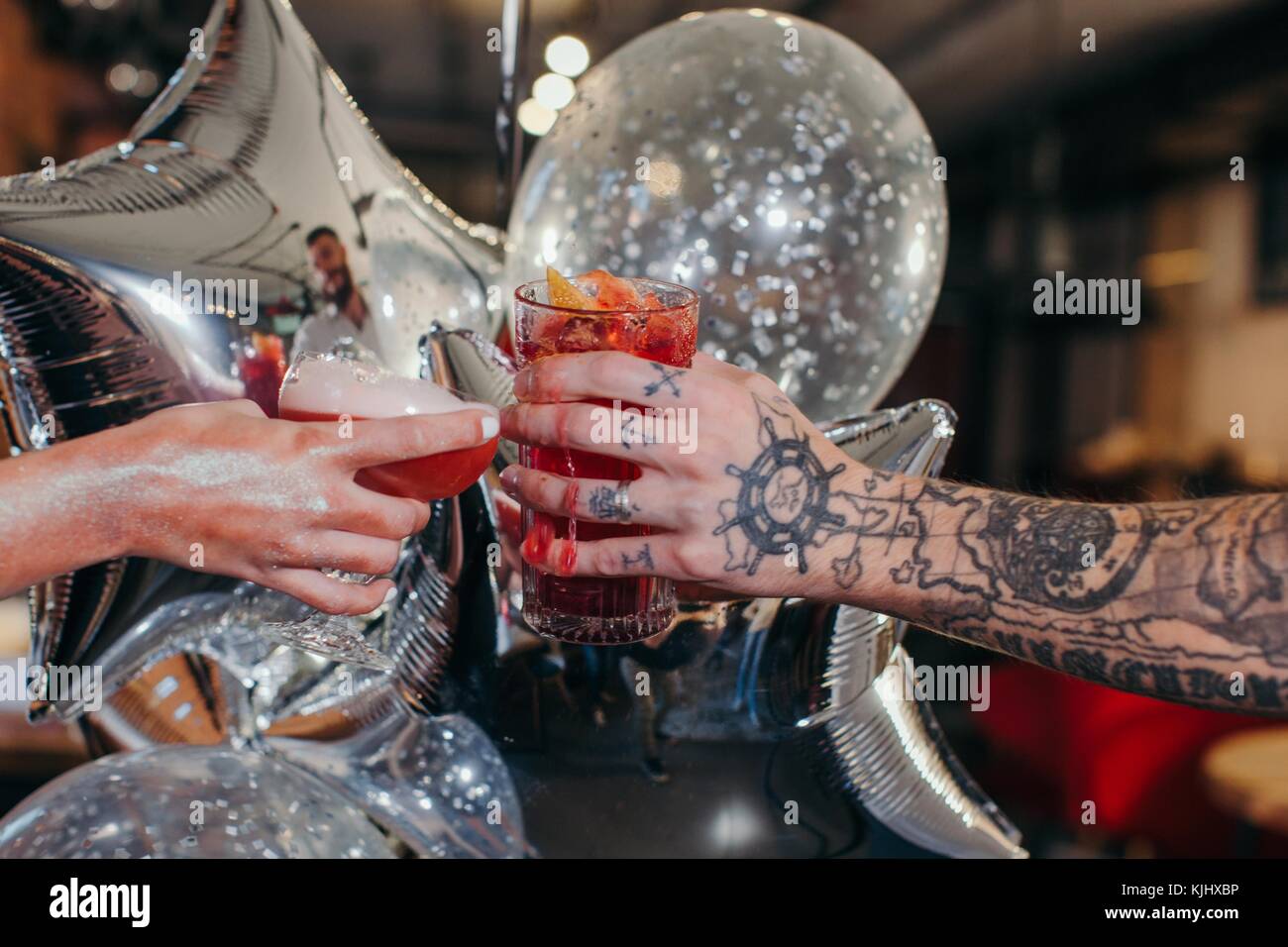 Man and woman in a bar making a celebratory toast Stock Photo - Alamy