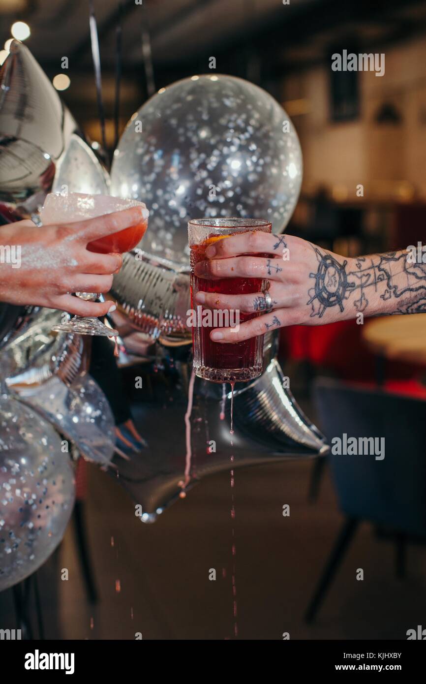 Man and woman in a bar making a celebratory toast Stock Photo - Alamy