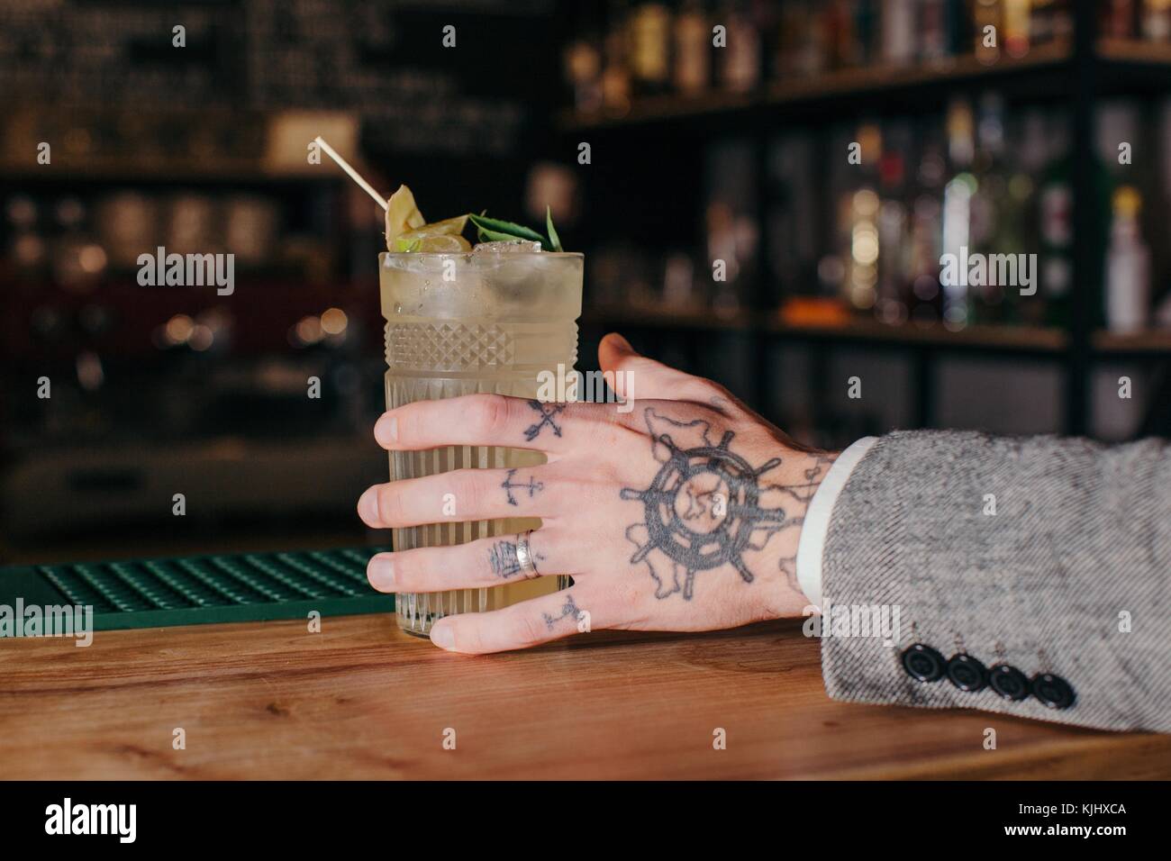 Man's hand reaching for a cocktail in a bar Stock Photo - Alamy