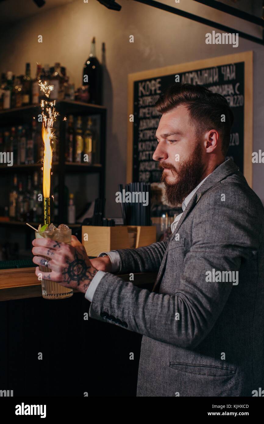Man in a bar holding a cocktail Stock Photo - Alamy