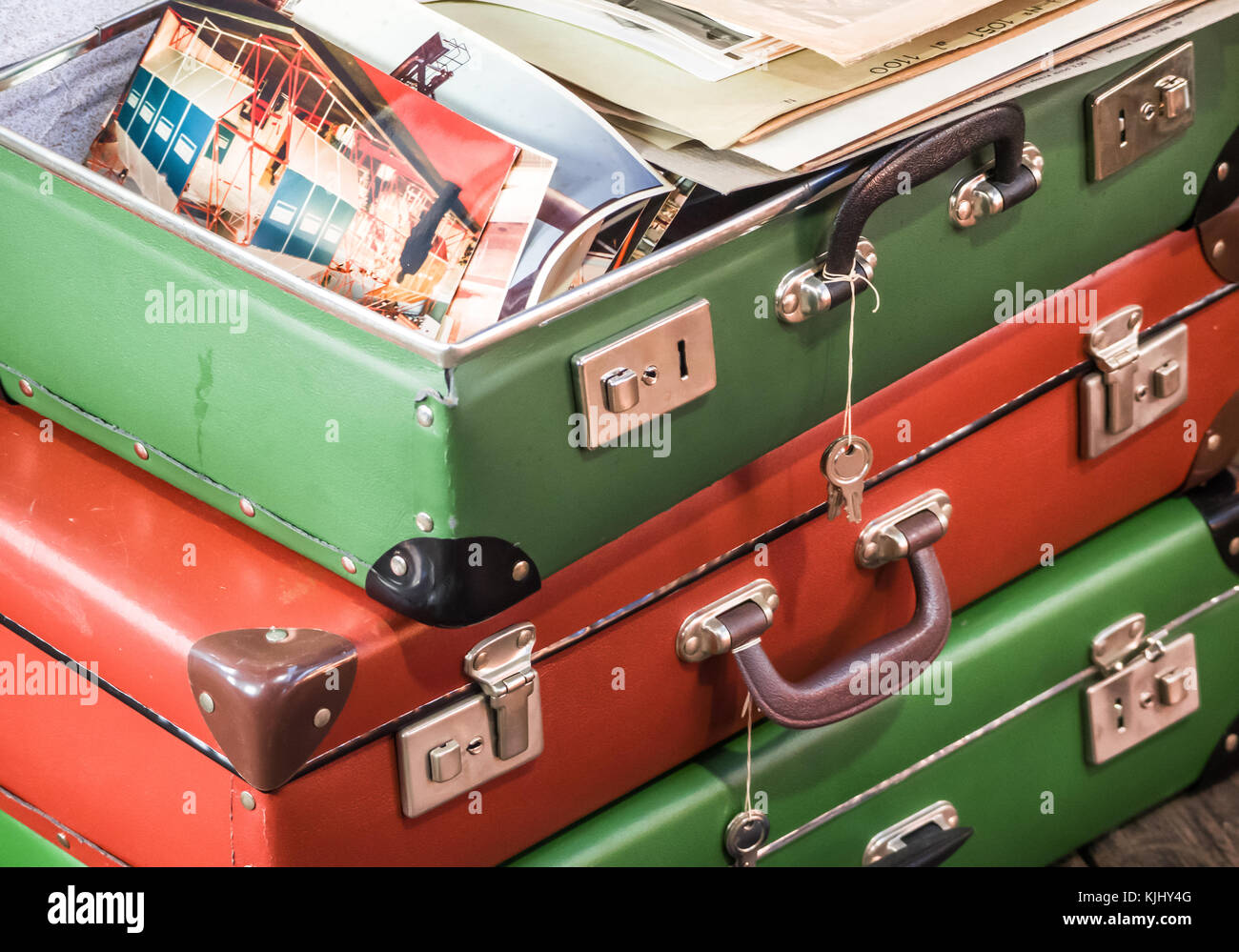 orange and green colored leather briefcases, containing old photographs ...