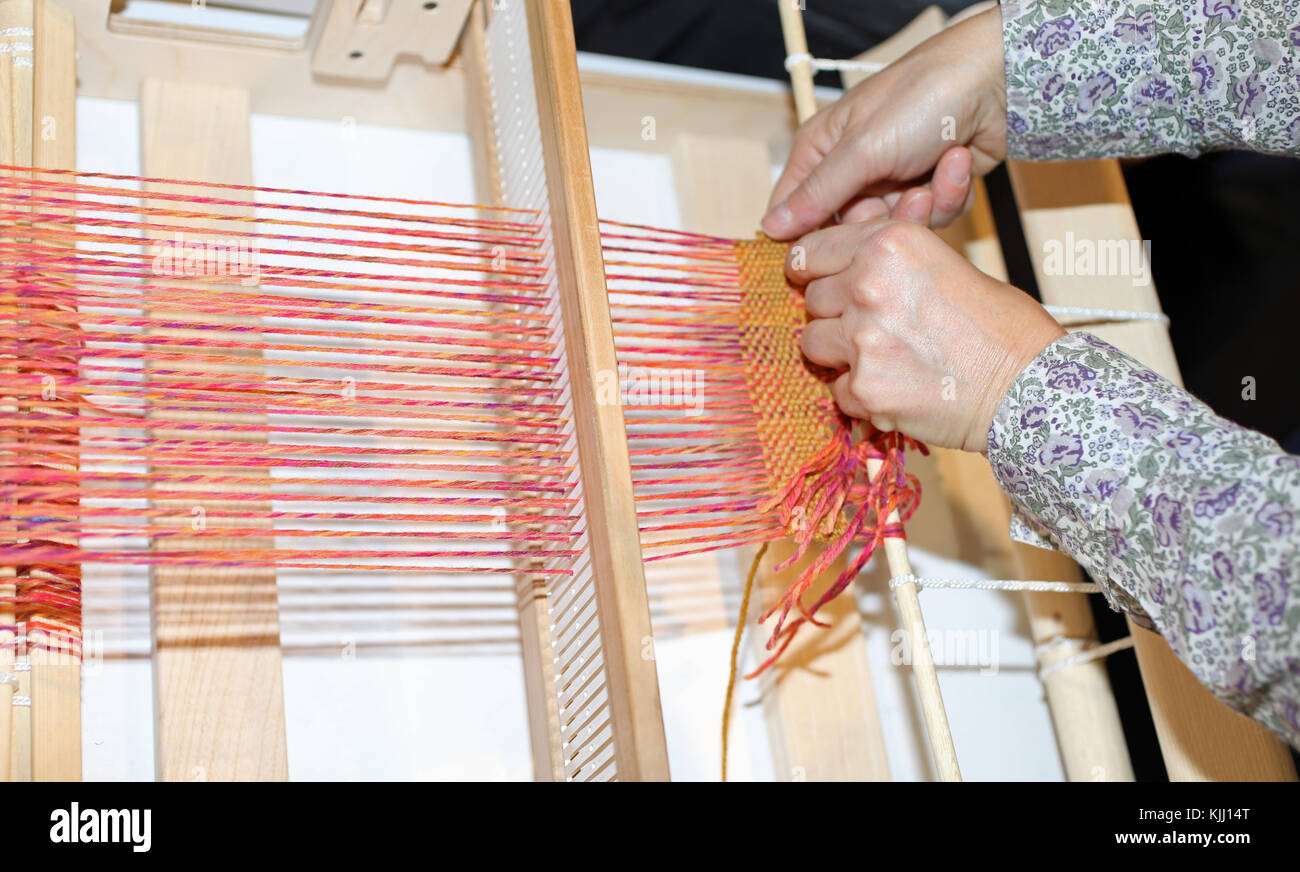 worker with wood frame for spinning fabrics and colored threads Stock ...