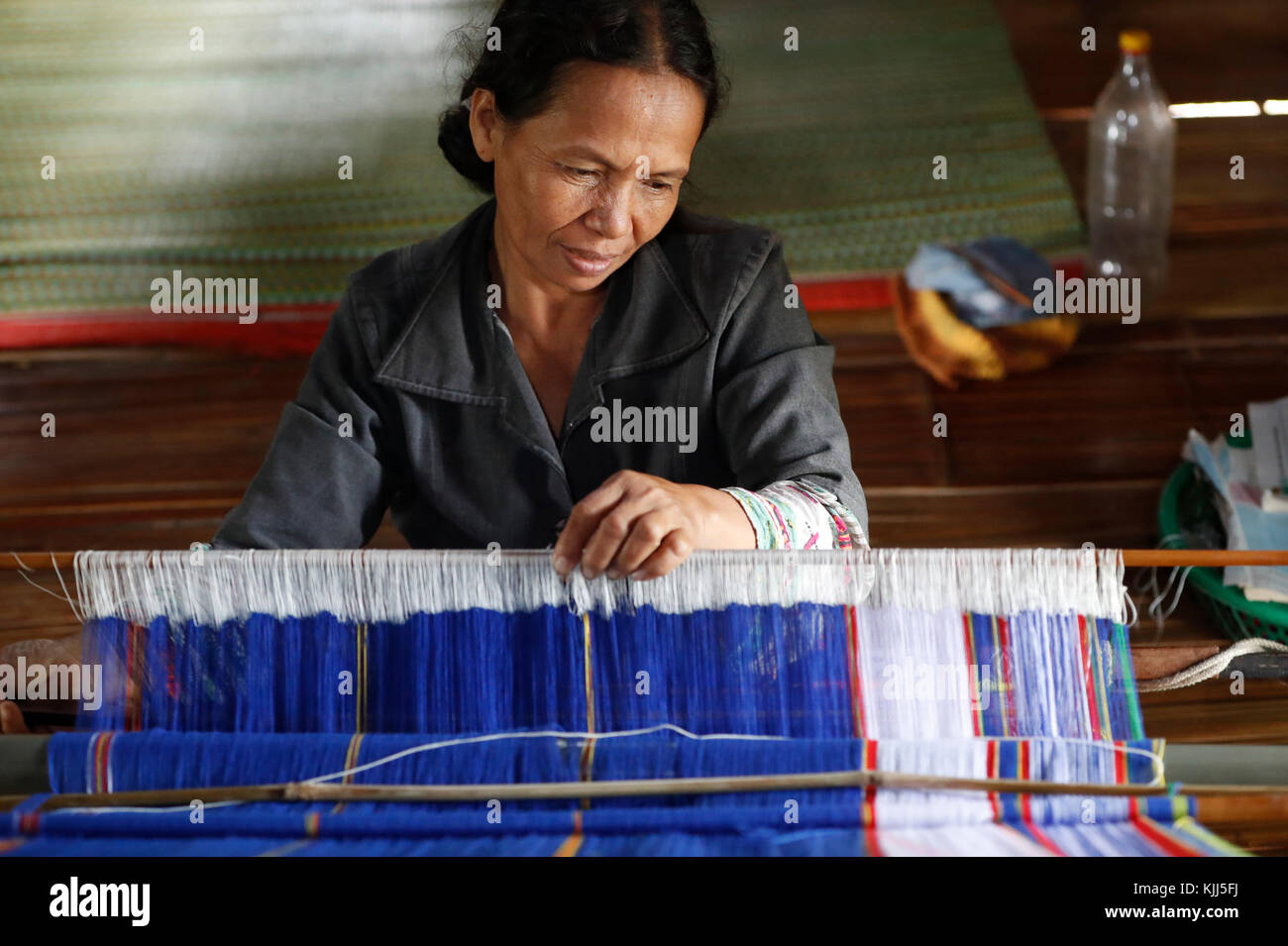 Bahnar (Ba Na) ethnic group. Woman weaving silk at wooden loom. Kon Tum ...