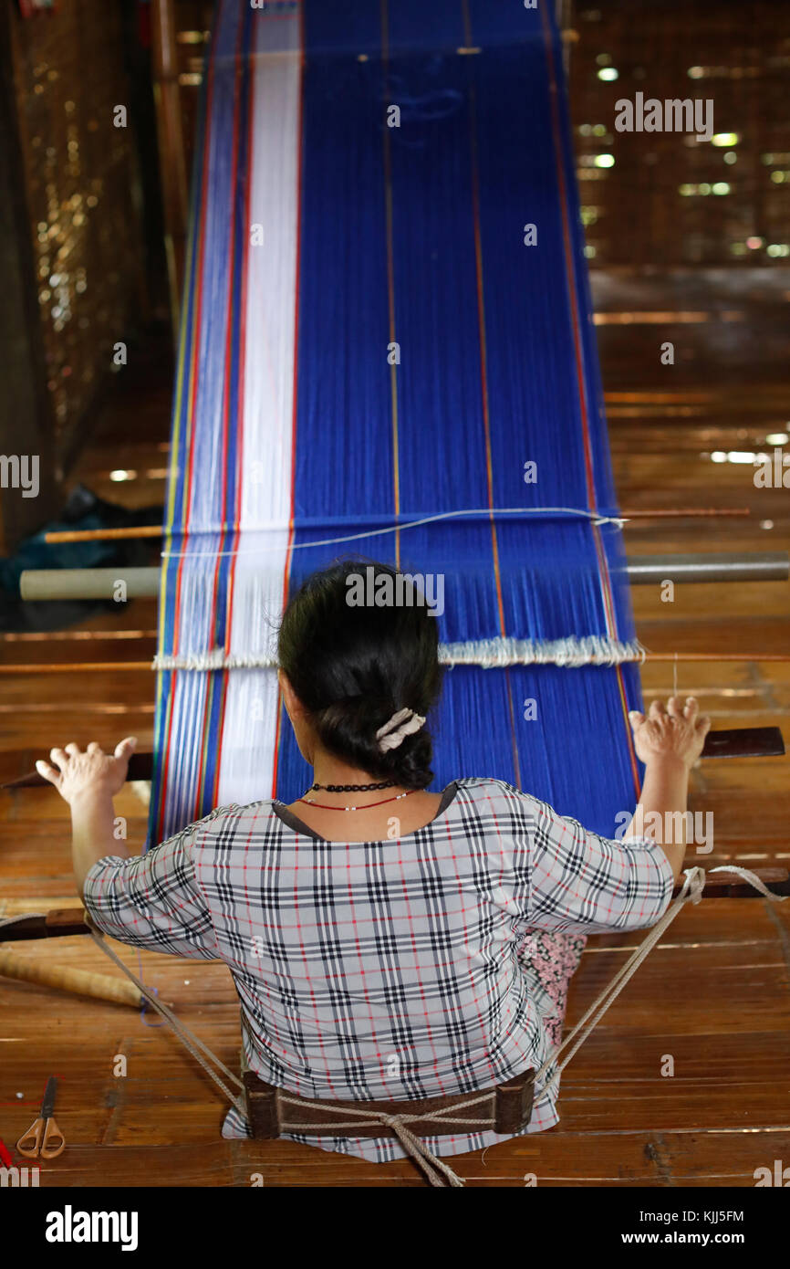 Bahnar (Ba Na) ethnic group. Woman weaving silk at wooden loom. Kon Tum ...