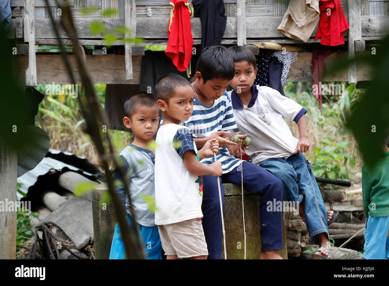 Bahnar (Ba Na) ethnic group. Group of young boys playing outside. Kon ...