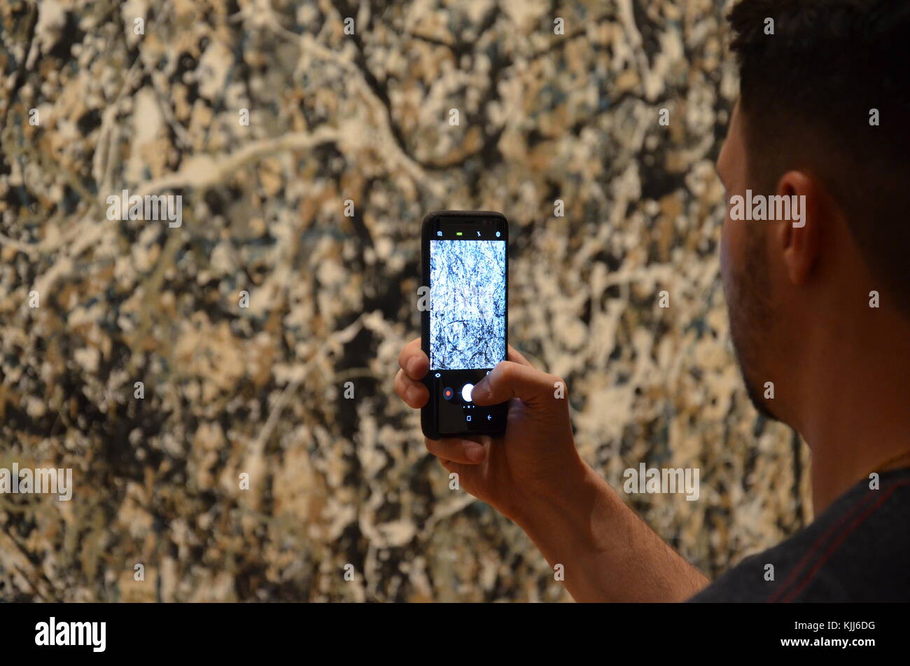Man taking photograph on cellphone of Jackson Pollock's painting, 'One ...
