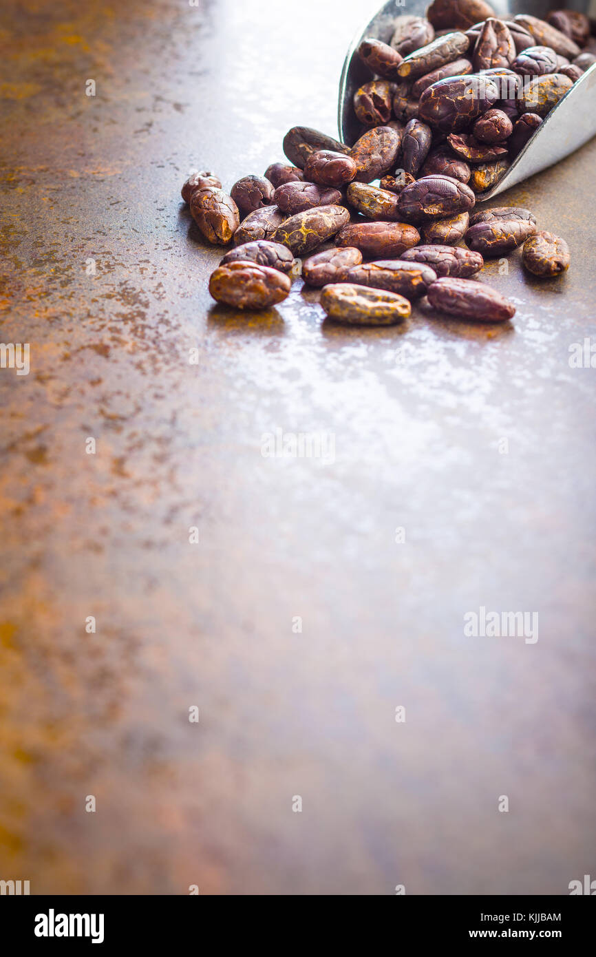 Dark cocoa beans on rusty background Stock Photo - Alamy