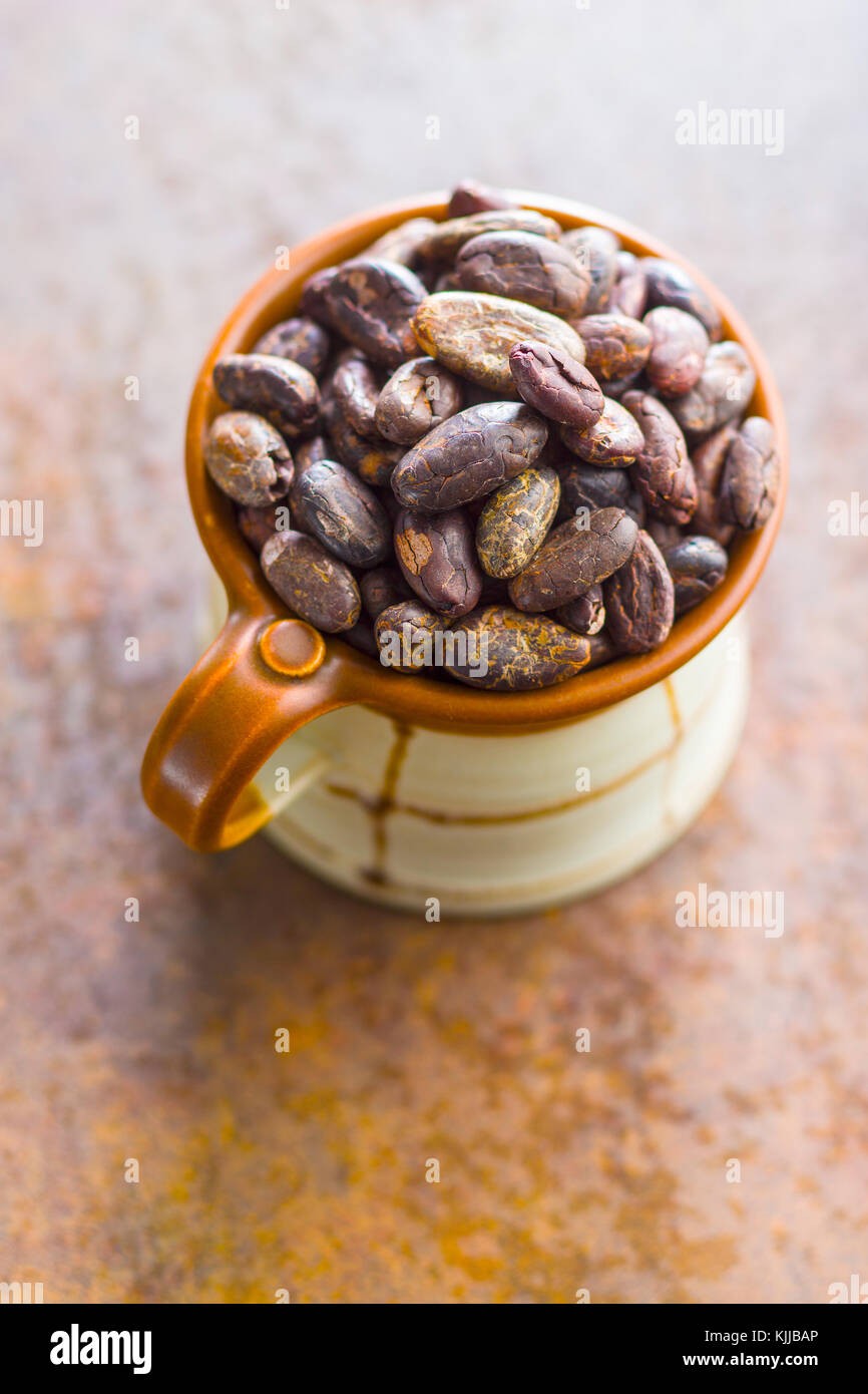 Dark cocoa beans in mug Stock Photo - Alamy