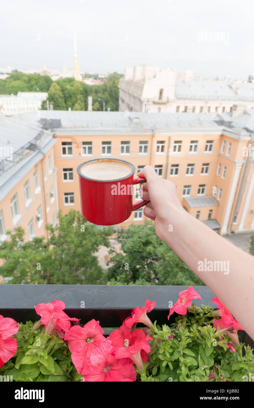 Woman drinking coffee outdoor on balcony outdoor. Hand with red coffee ...