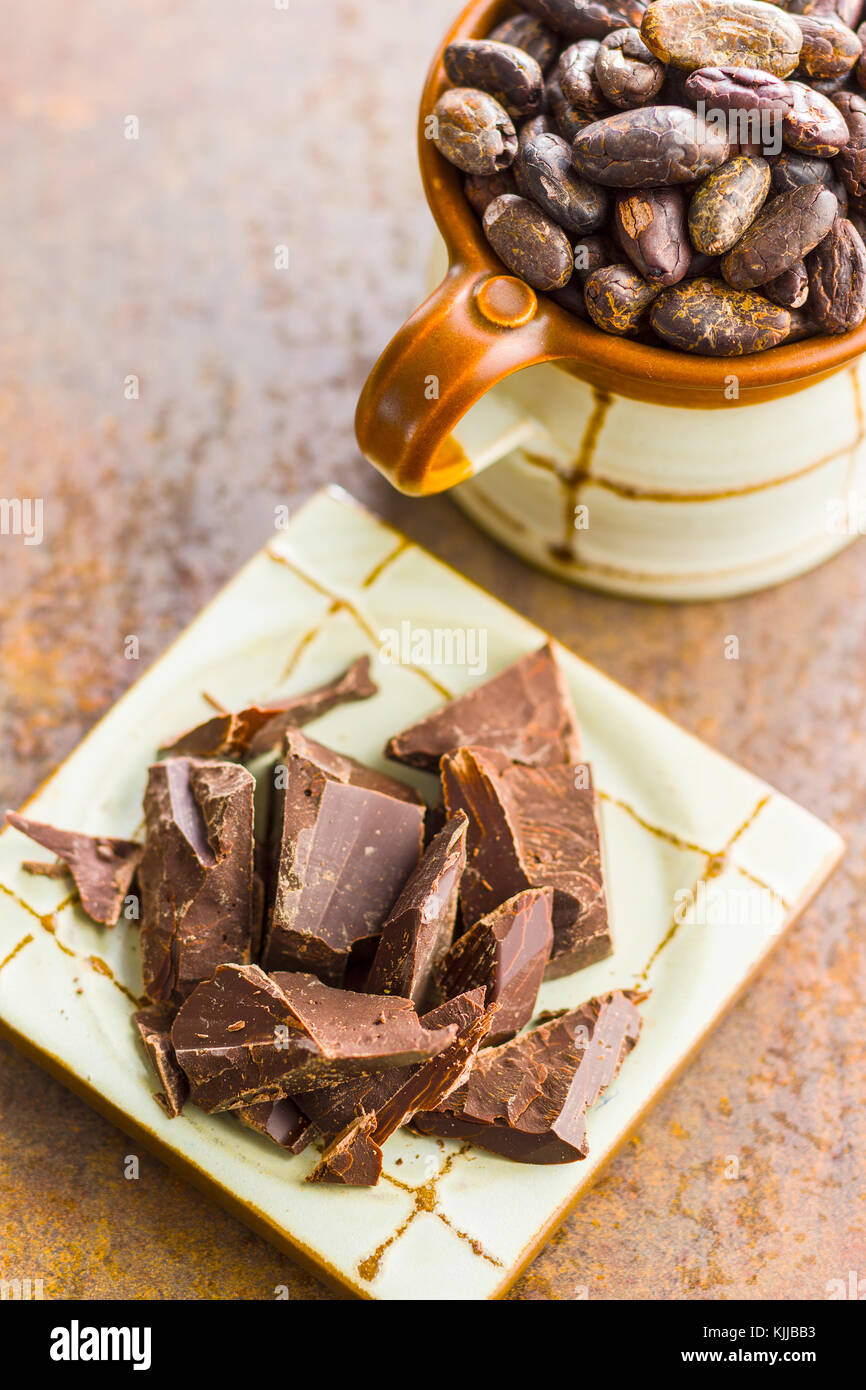 Dark chocolate and cocoa beans on rusty background Stock Photo - Alamy