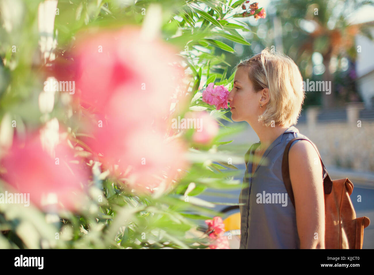 Young woman enjoying smelling aroma flowers outdoors Stock Photo - Alamy