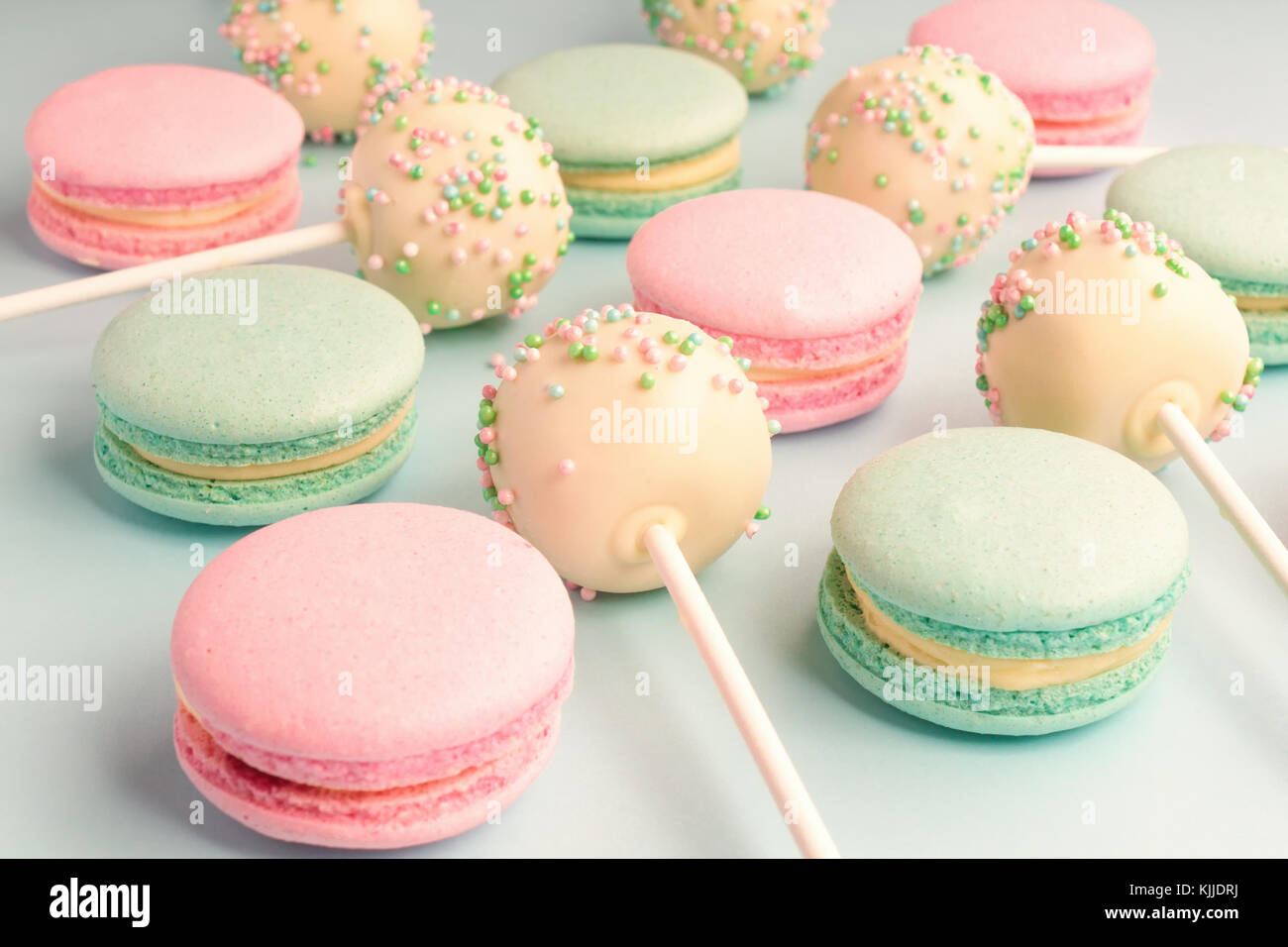 Close-up of macaroons mixed with cake pops with icing on sticks Stock ...