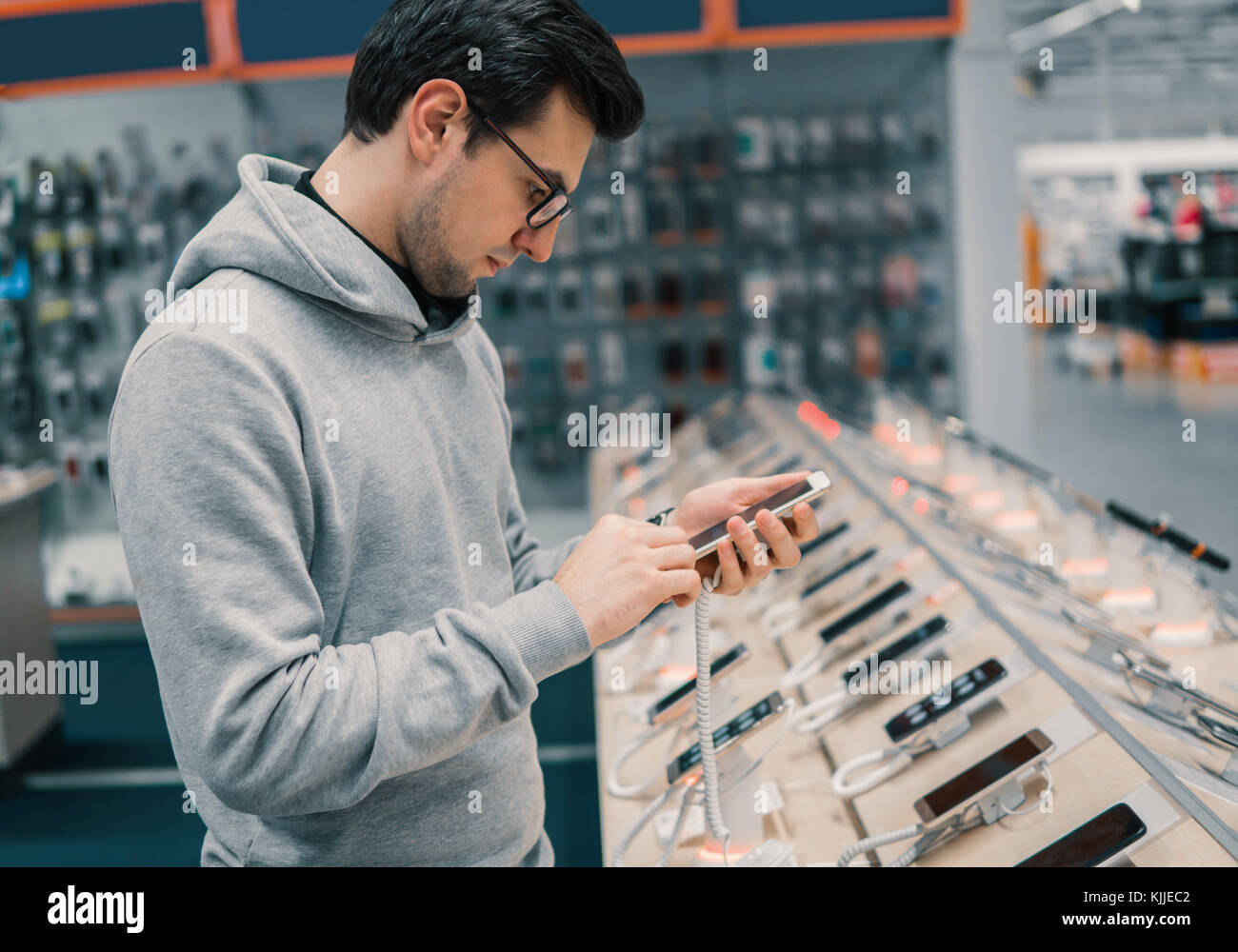 Happy male customer choosing smartphone in the mobile phone shop ...