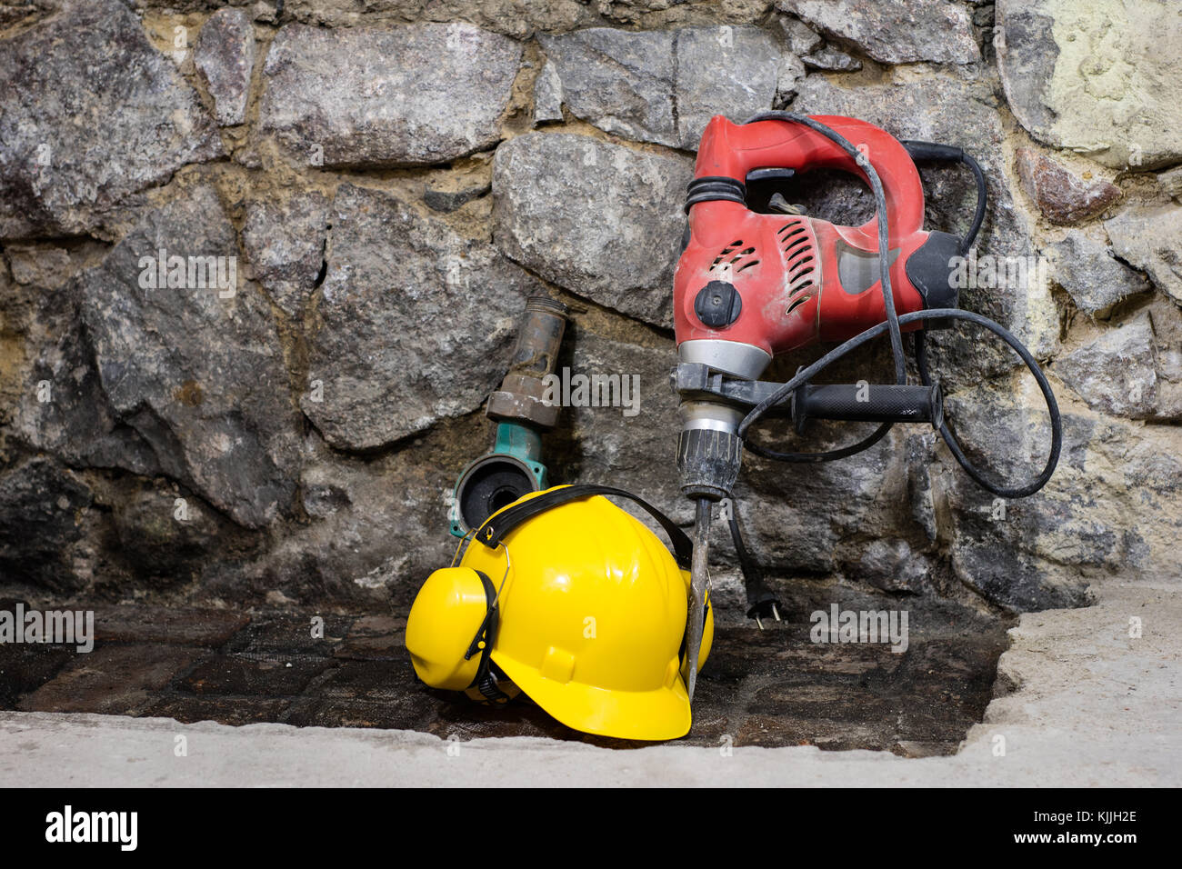 Construction tools for building a house on a stone wall. Hammer, helmet ...
