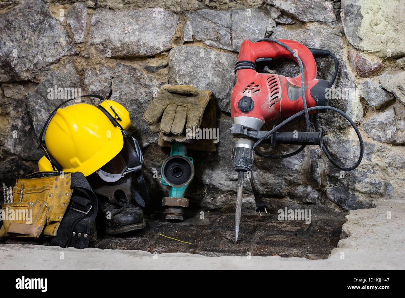 Construction tools for building a house on a stone wall. Hammer, helmet ...