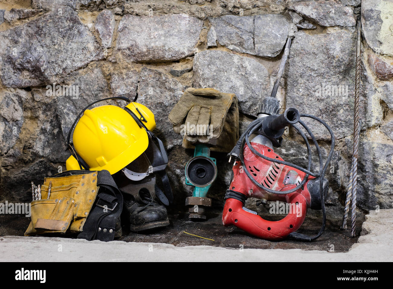 Construction tools for building a house on a stone wall. Hammer, helmet ...