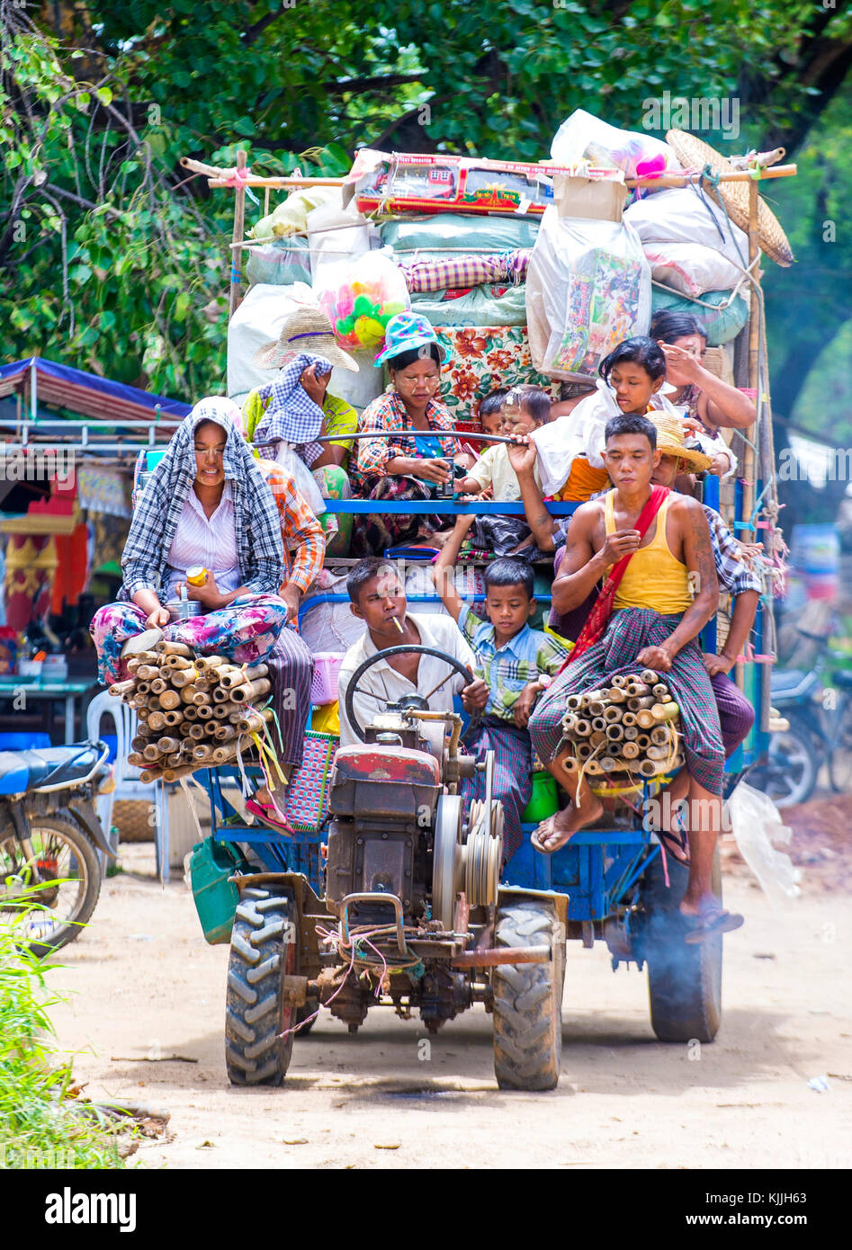 Burmese farmers riding on an old tractor in a village in Shan state ...