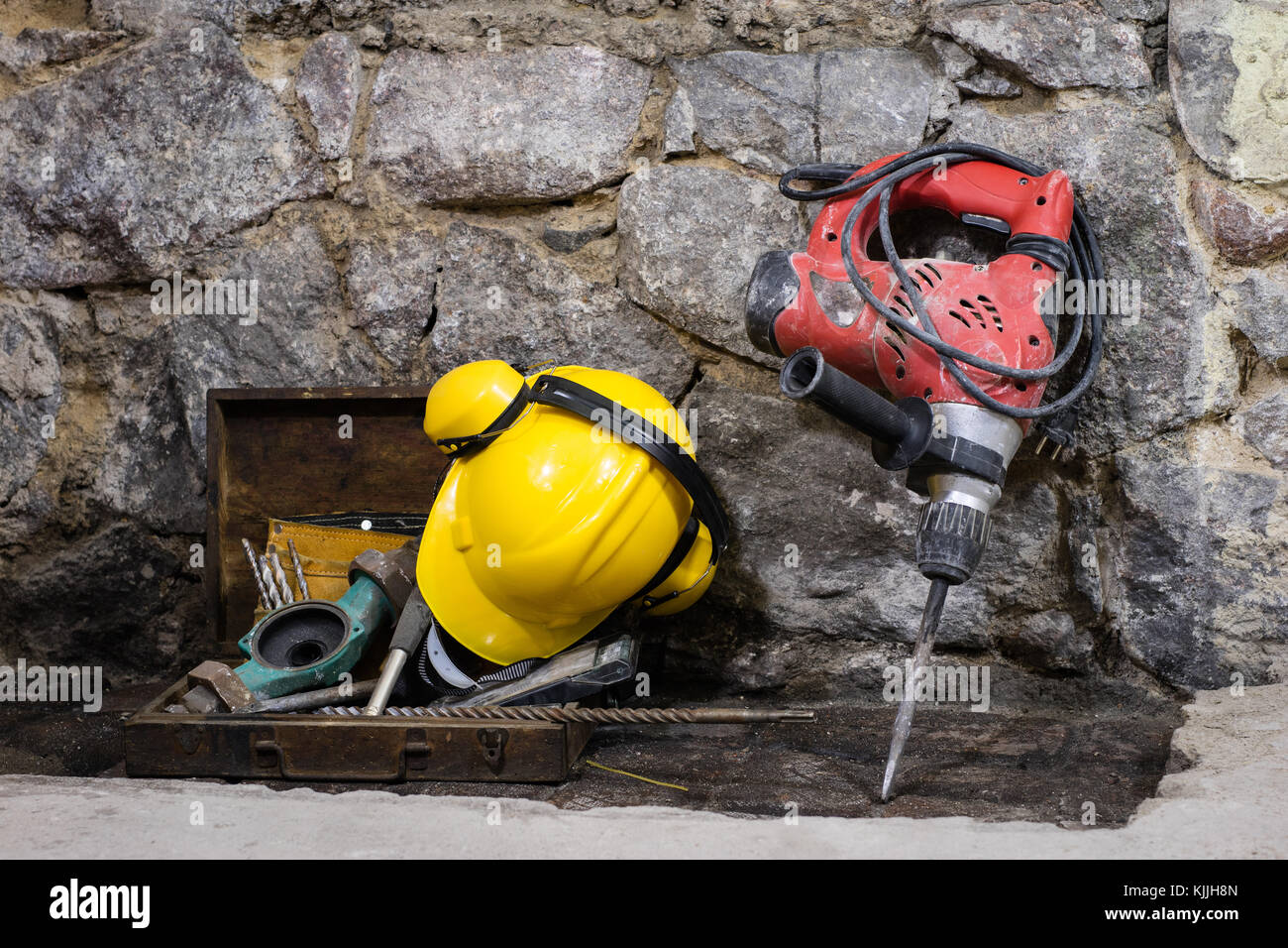 Construction tools for building a house on a stone wall. Hammer, helmet ...