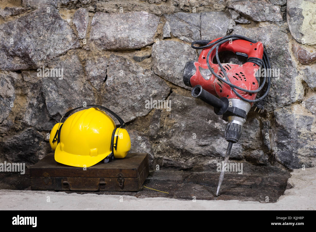 Construction tools for building a house on a stone wall. Hammer, helmet ...
