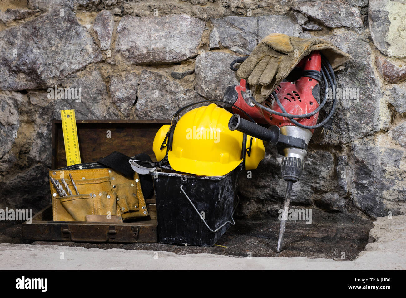 Construction tools for building a house on a stone wall. Hammer, helmet ...