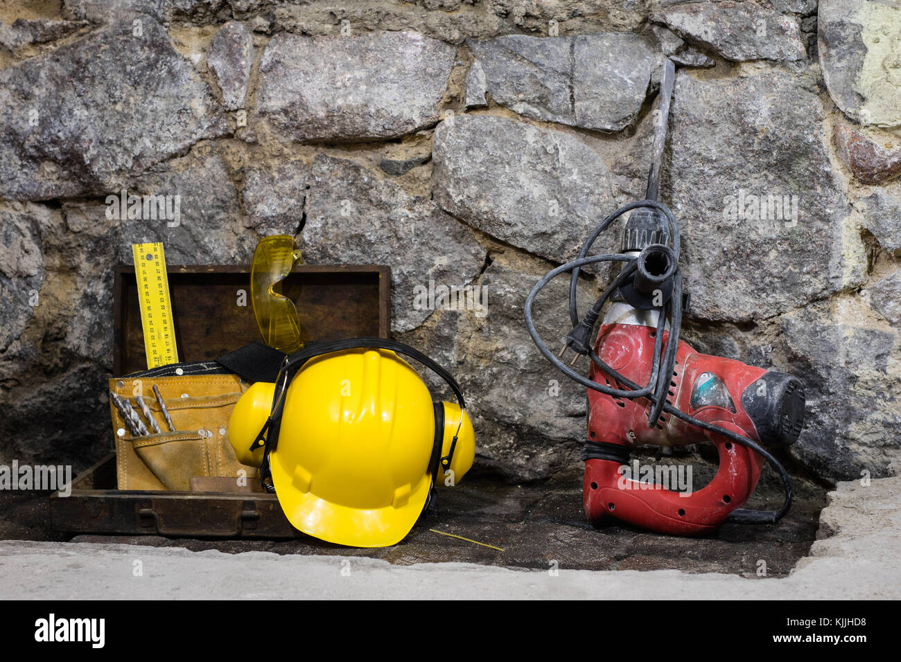 Construction tools for building a house on a stone wall. Hammer, helmet ...