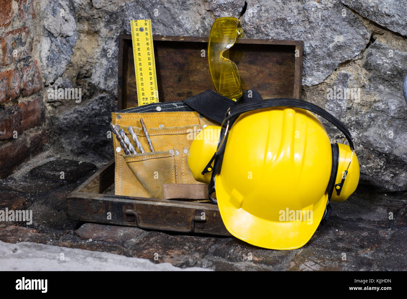 Construction tools for building a house on a stone wall. Hammer, helmet ...